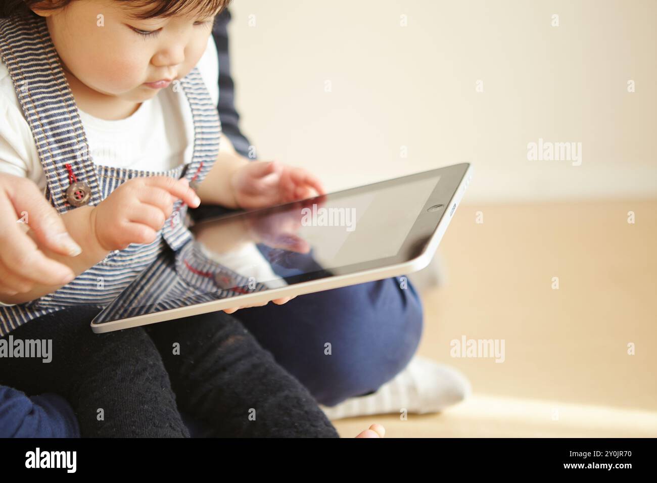 Girl looking at tablet with mom Stock Photo - Alamy