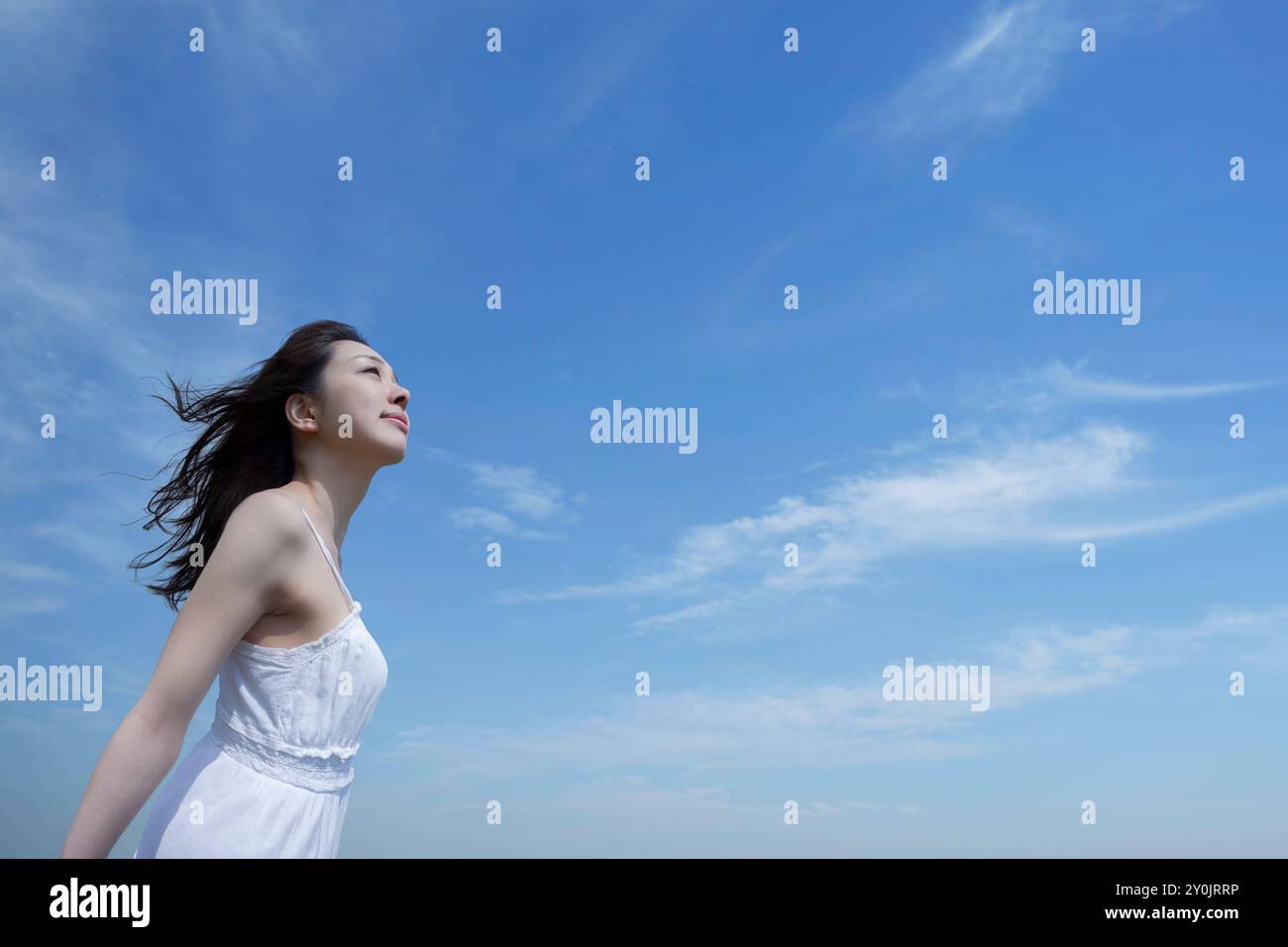 Woman looking up the sky under the urban blue sky Stock Photo - Alamy