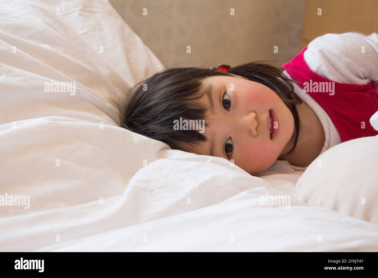 Girl putting her face to the futon Stock Photo - Alamy