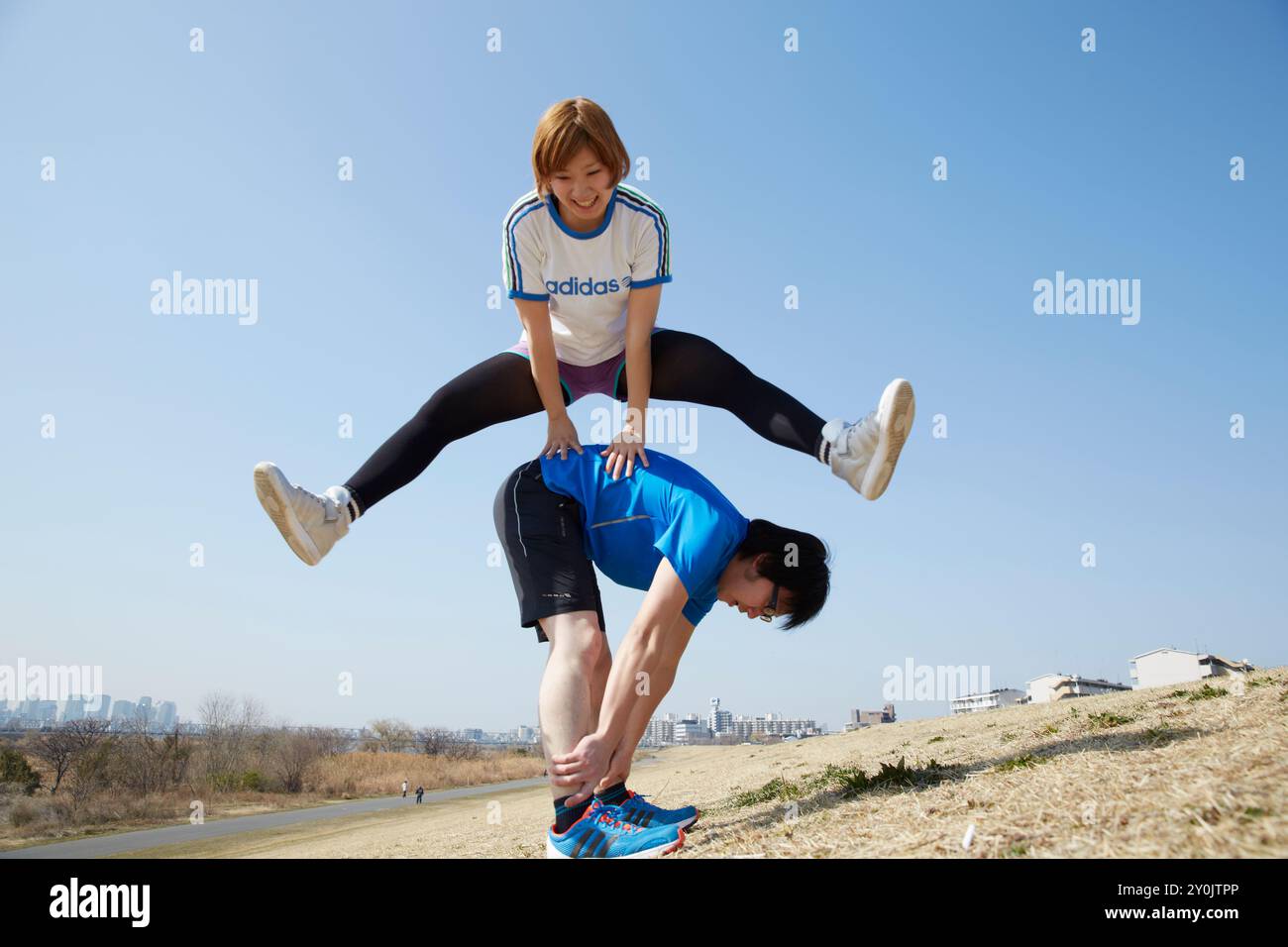 Man and woman leapfrogging on a river bed Stock Photo - Alamy
