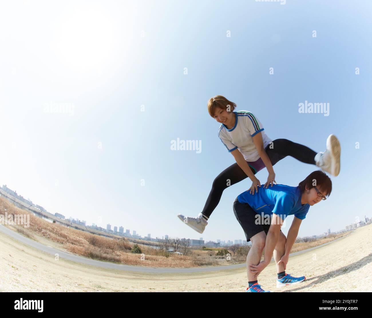 Man and woman leapfrogging on a river bed Stock Photo - Alamy