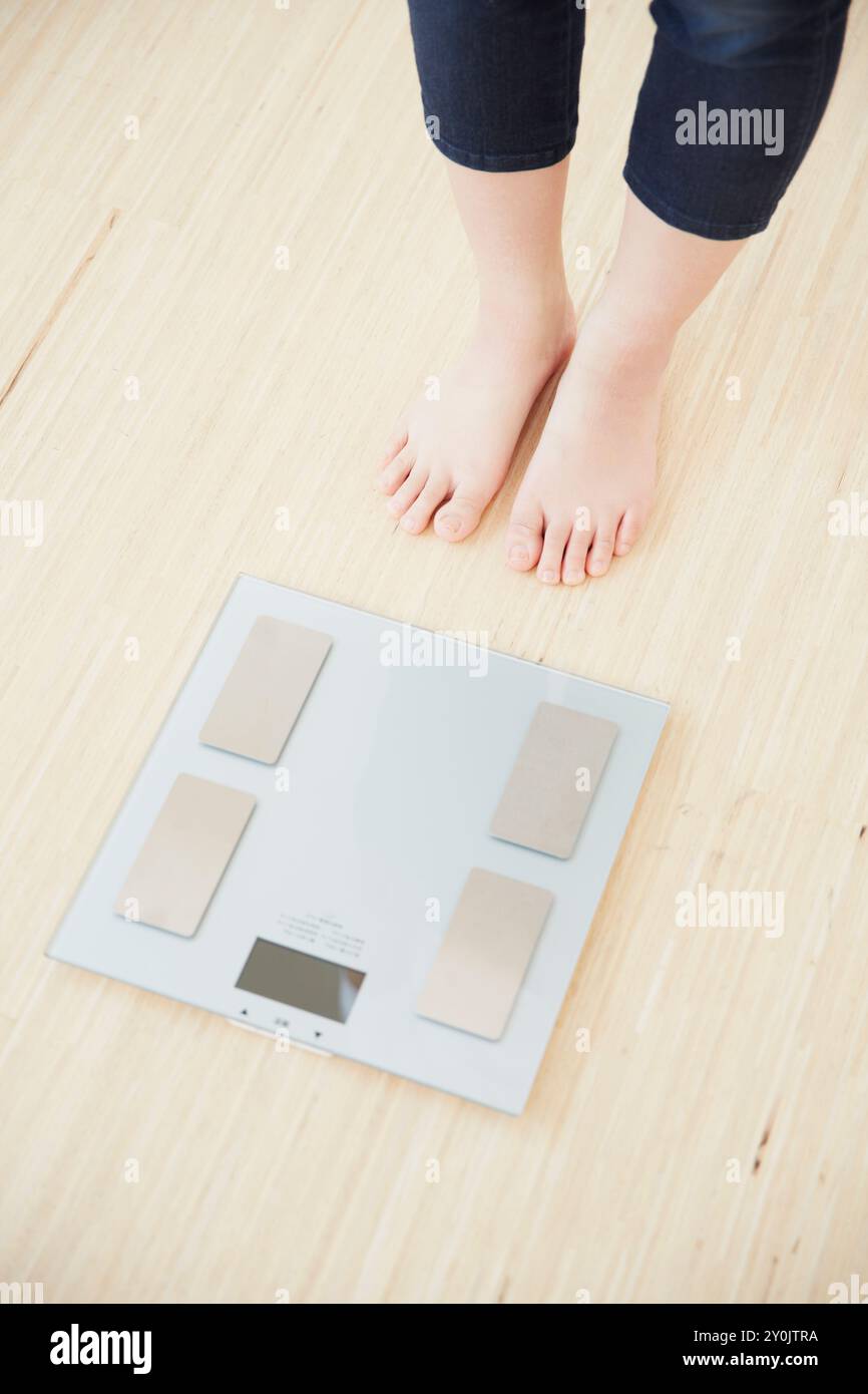 Weighing scale and feet of a woman Stock Photo - Alamy