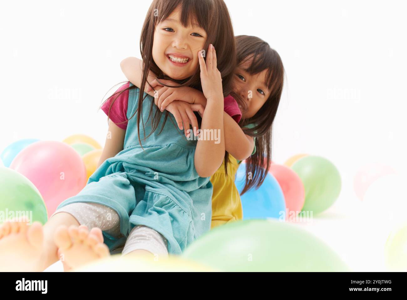 Twin sisters playing with ballonns Stock Photo - Alamy