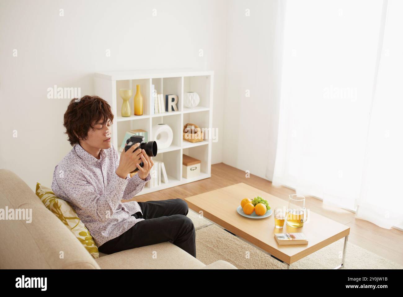 Man touching the camera sitting on the sofa Stock Photo - Alamy