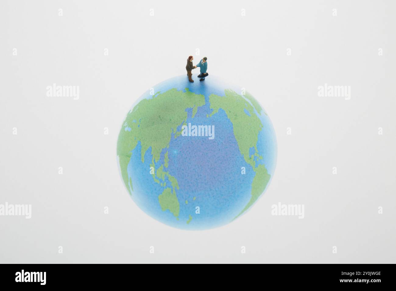 Two figures shaking hands on the Earth Stock Photo - Alamy