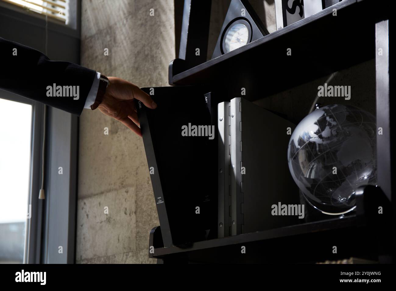Hand of businessman taking the file out from the bookshelf Stock Photo ...