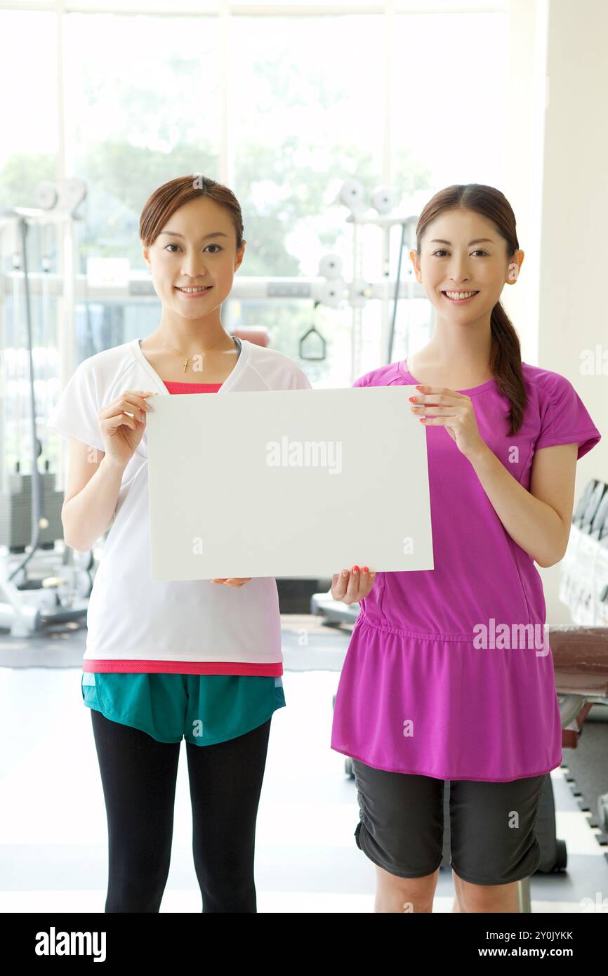 Two women holding message boards Stock Photo - Alamy