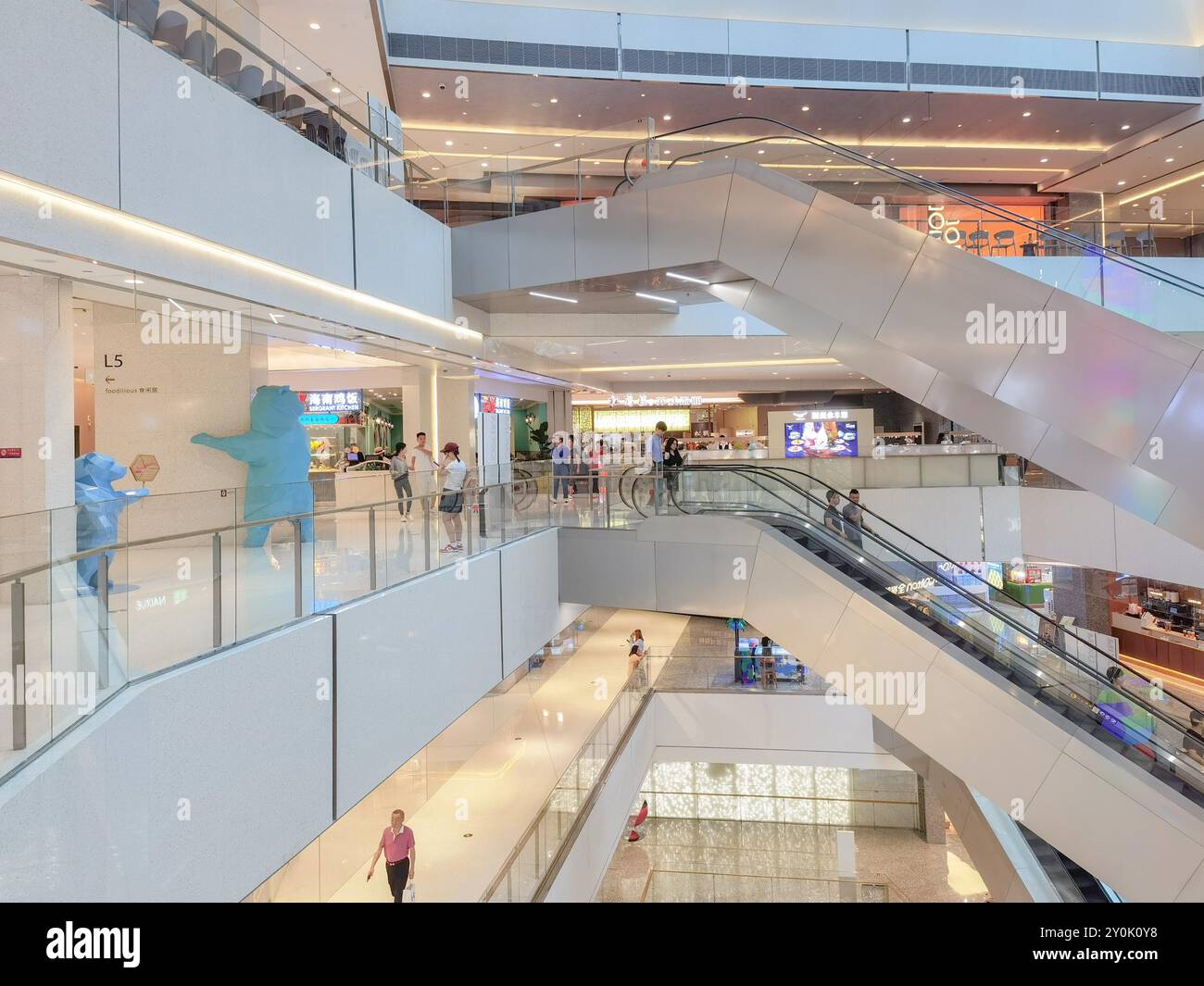 Shenzhen, China - September 02, 2024 : A modern, multi-level shopping mall with escalators ...