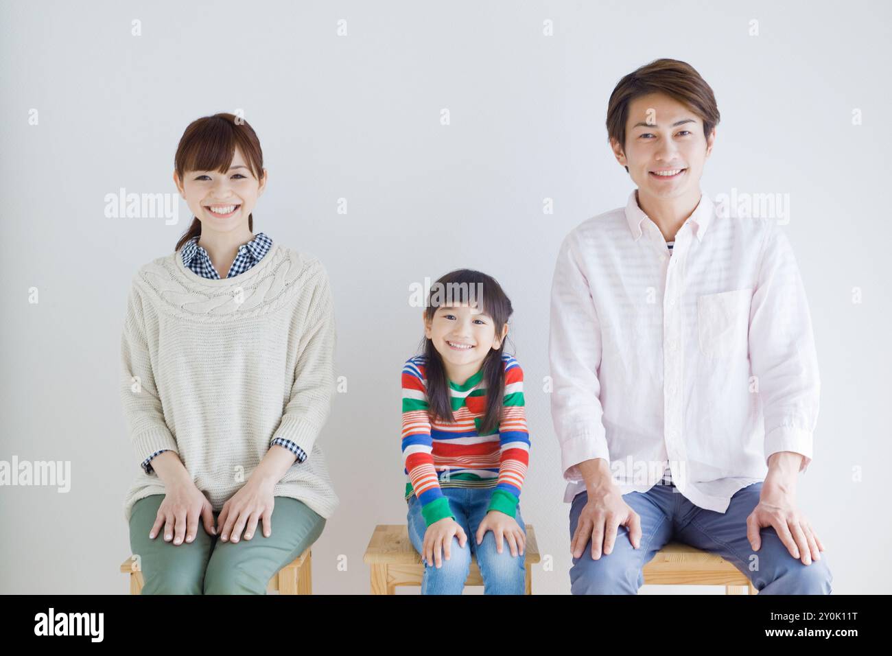 Smiling family sitting on chairs Stock Photo - Alamy