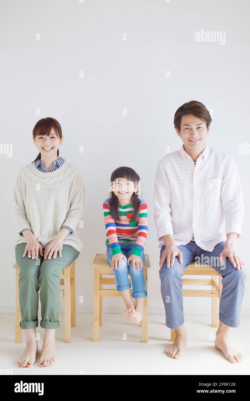 Smiling family sitting on chairs Stock Photo - Alamy