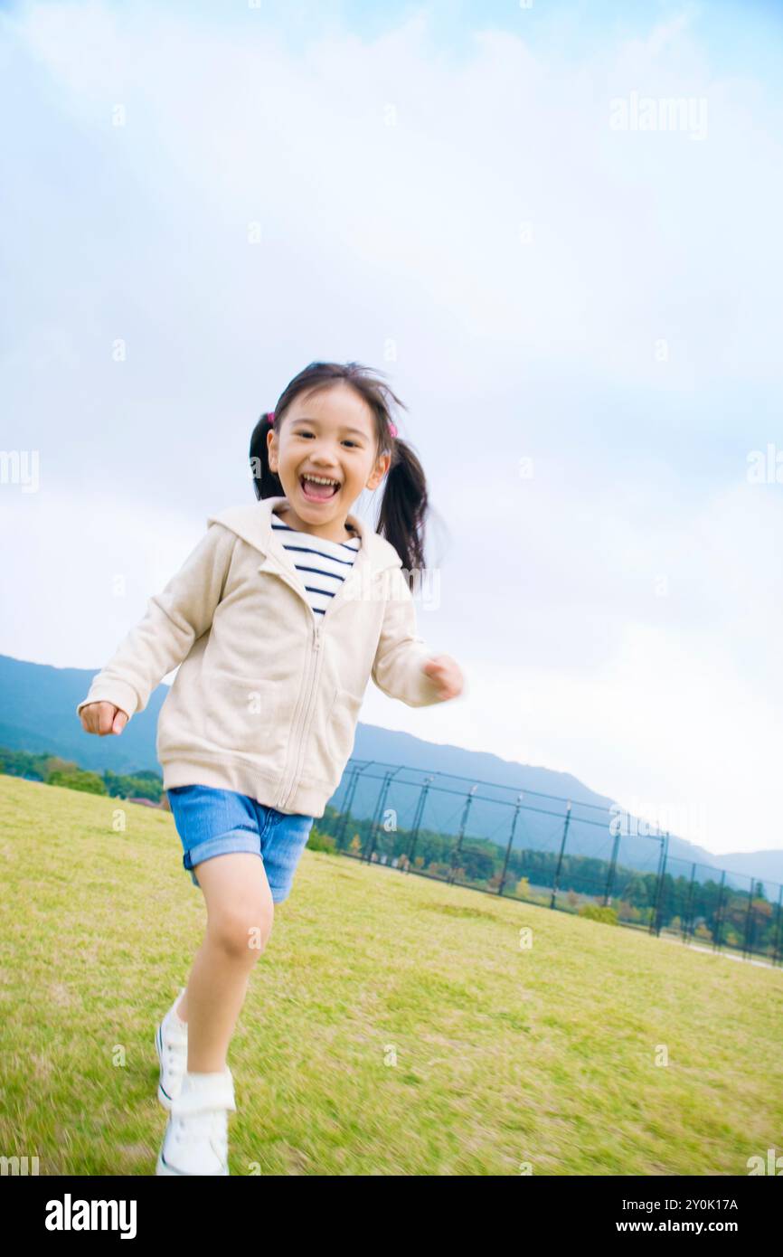 Girl running with a smile Stock Photo - Alamy