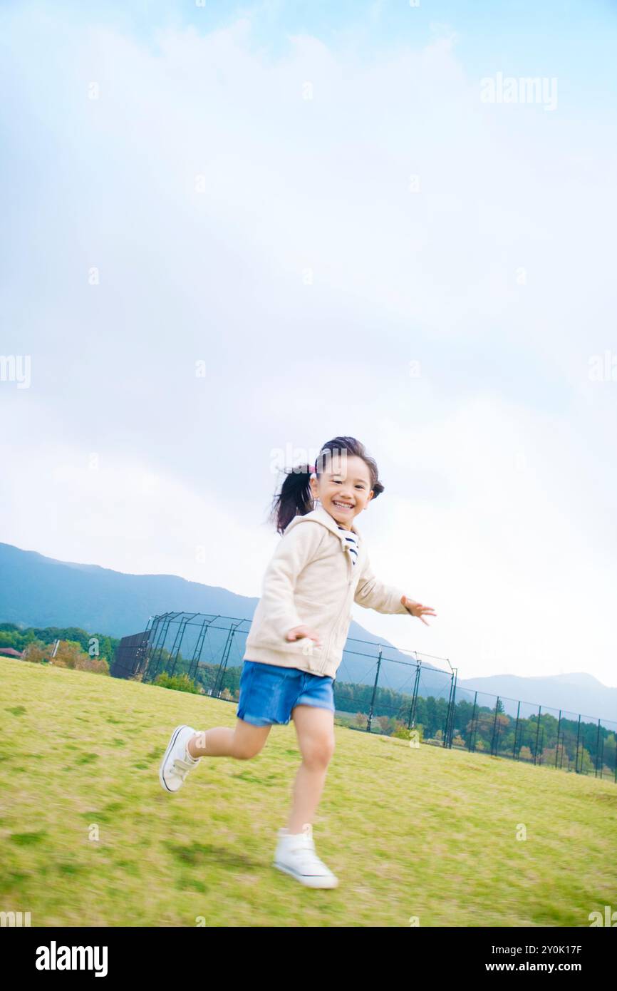 Girl running with a smile Stock Photo - Alamy