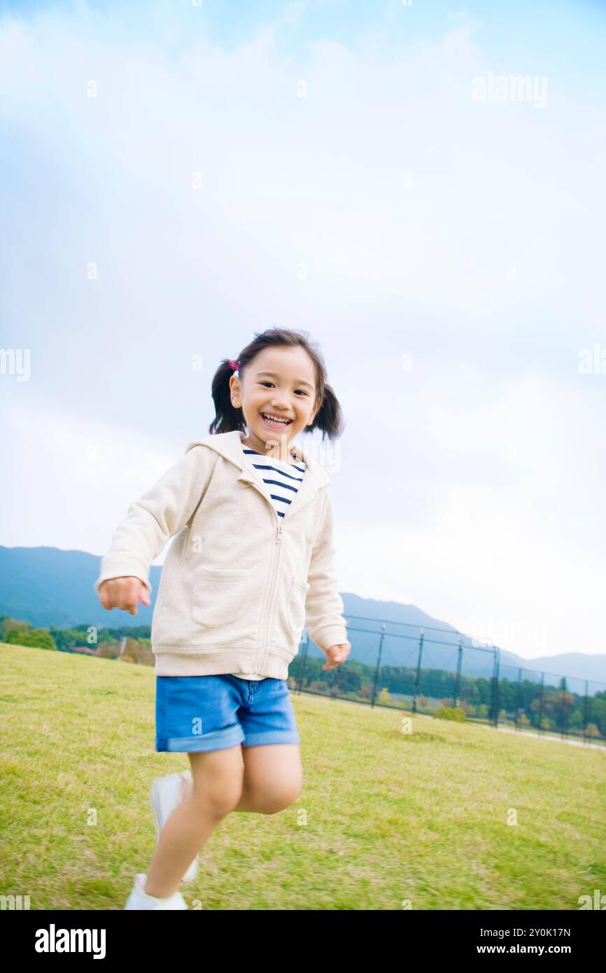 Girl running with a smile Stock Photo - Alamy