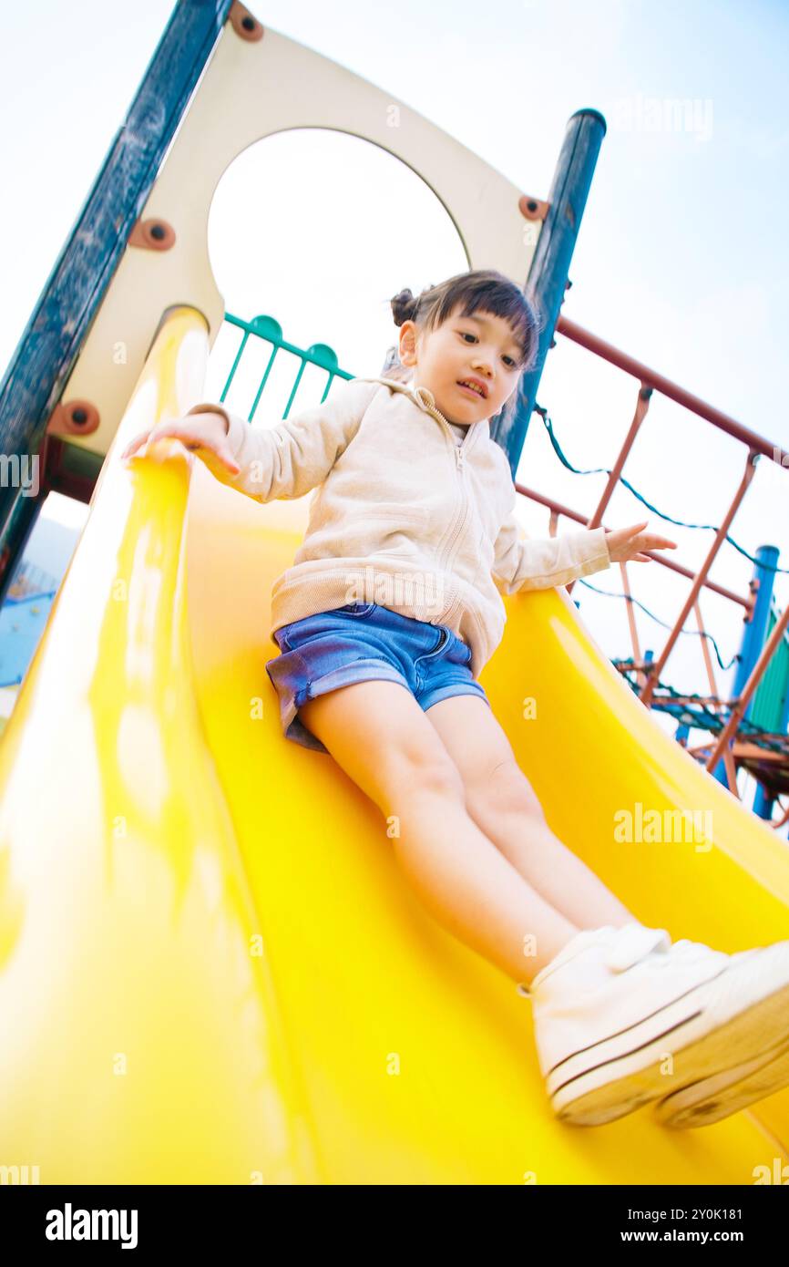 Girl playing on sliding way Stock Photo - Alamy