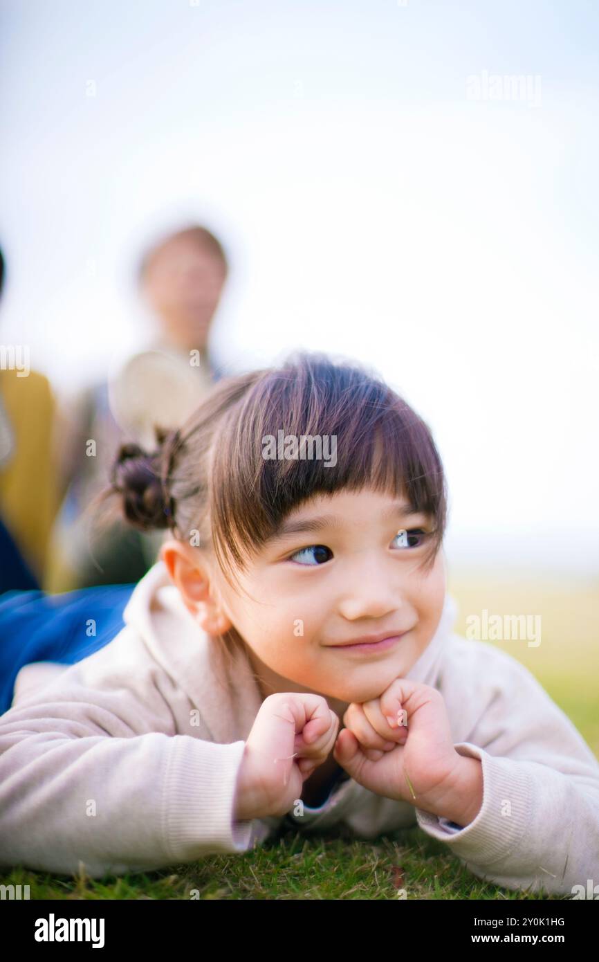 Girl lying sprawled on the grass Stock Photo - Alamy
