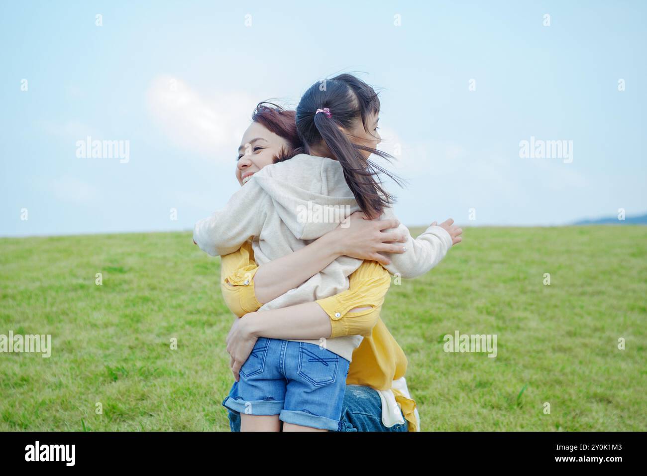 Mother hugging daughter Stock Photo - Alamy