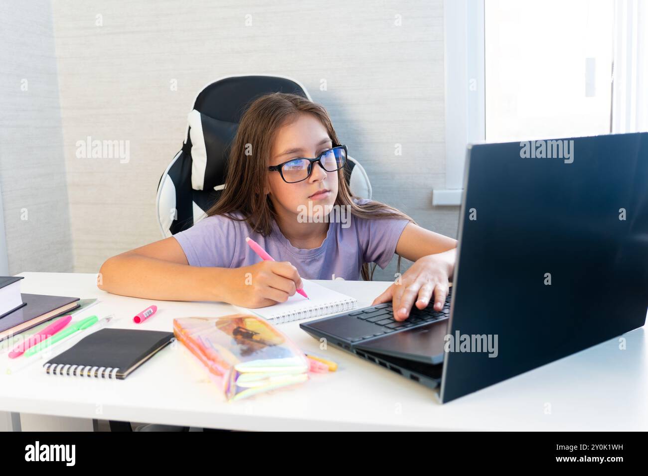 Teen girl school pupil studying online from home making notes. Teenage ...