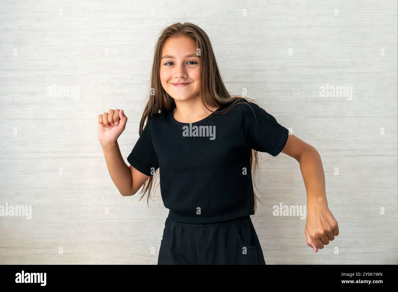 Portrait of attractive, happy girl with hair gathered in a bun. Wearing ...