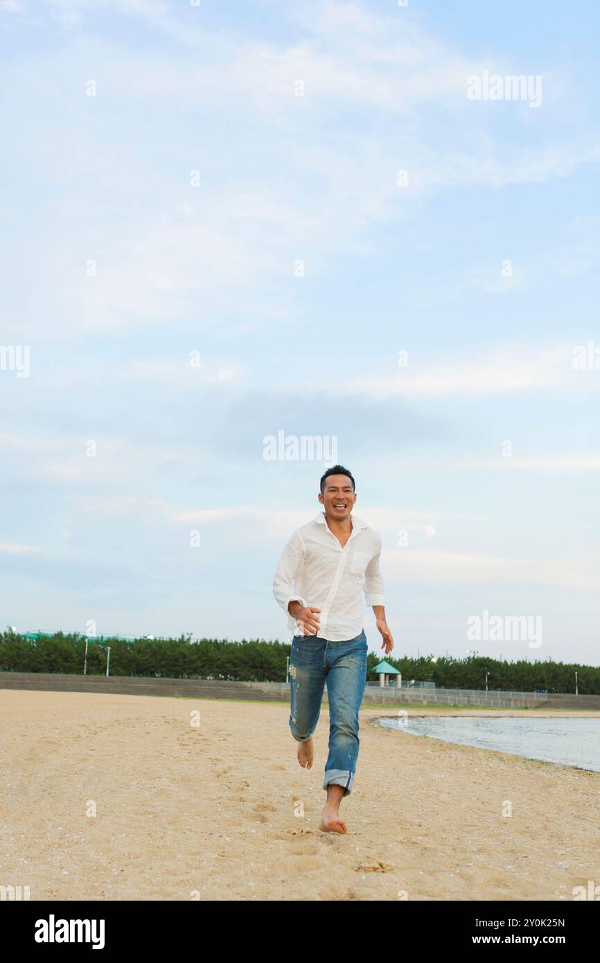 Japanese man running on the beach Stock Photo - Alamy