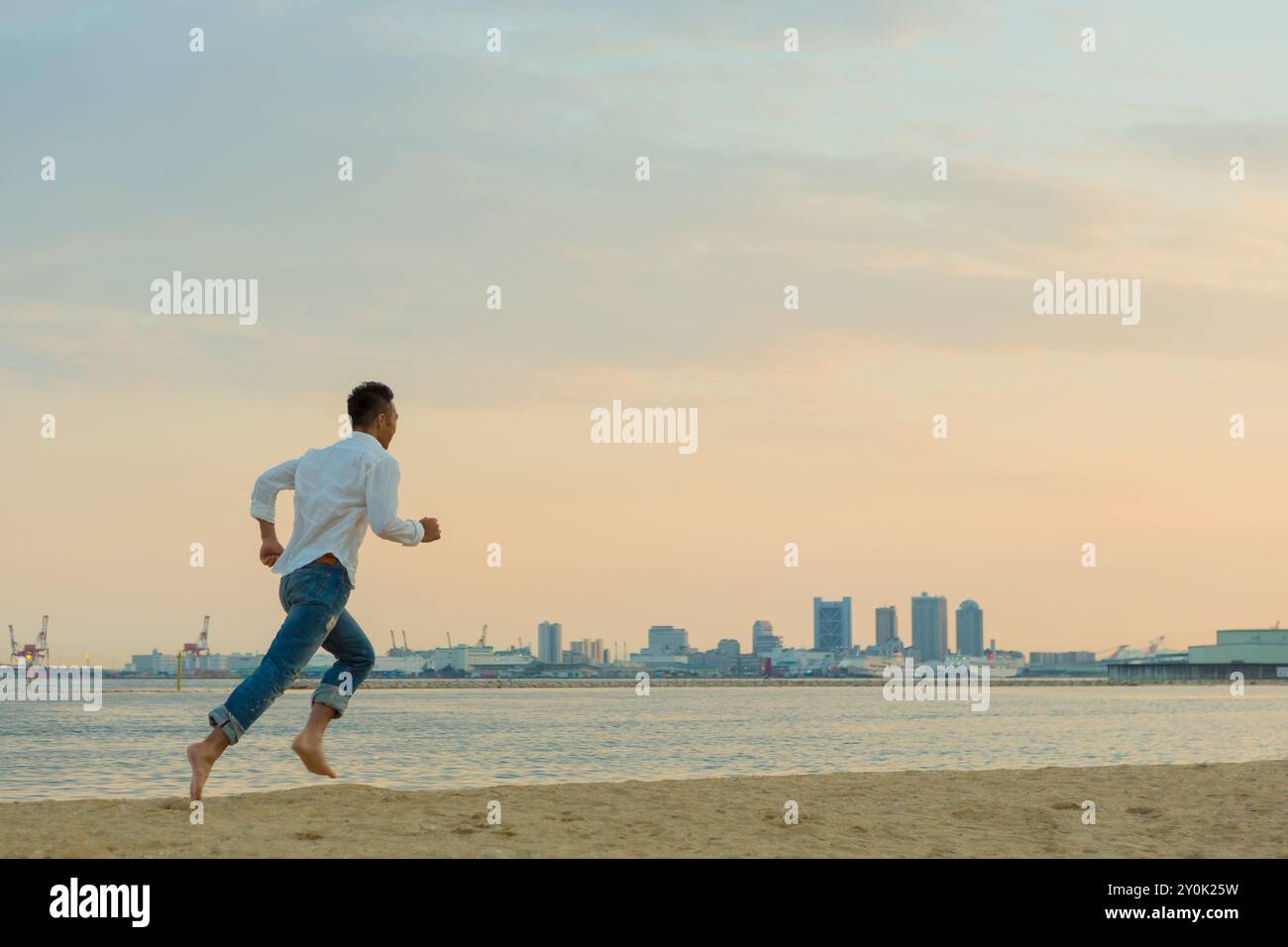 Japanese man running on the beach Stock Photo - Alamy