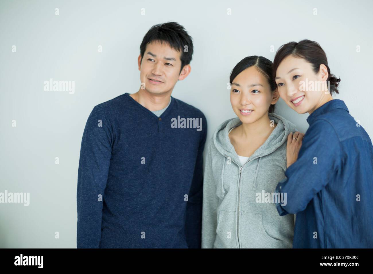 Three person family smiling Stock Photo - Alamy