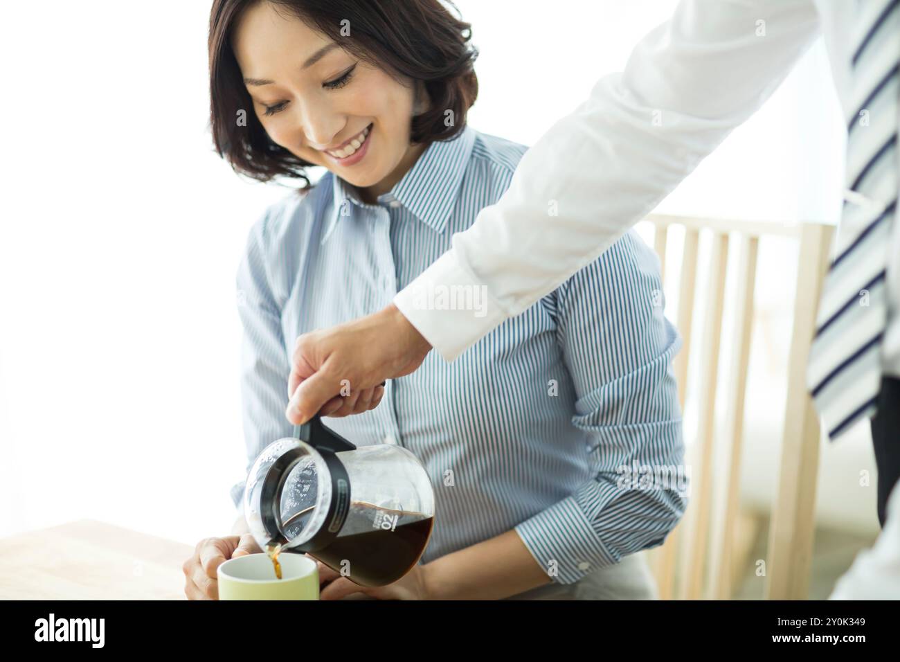Wife with coffee poured by husband Stock Photo - Alamy
