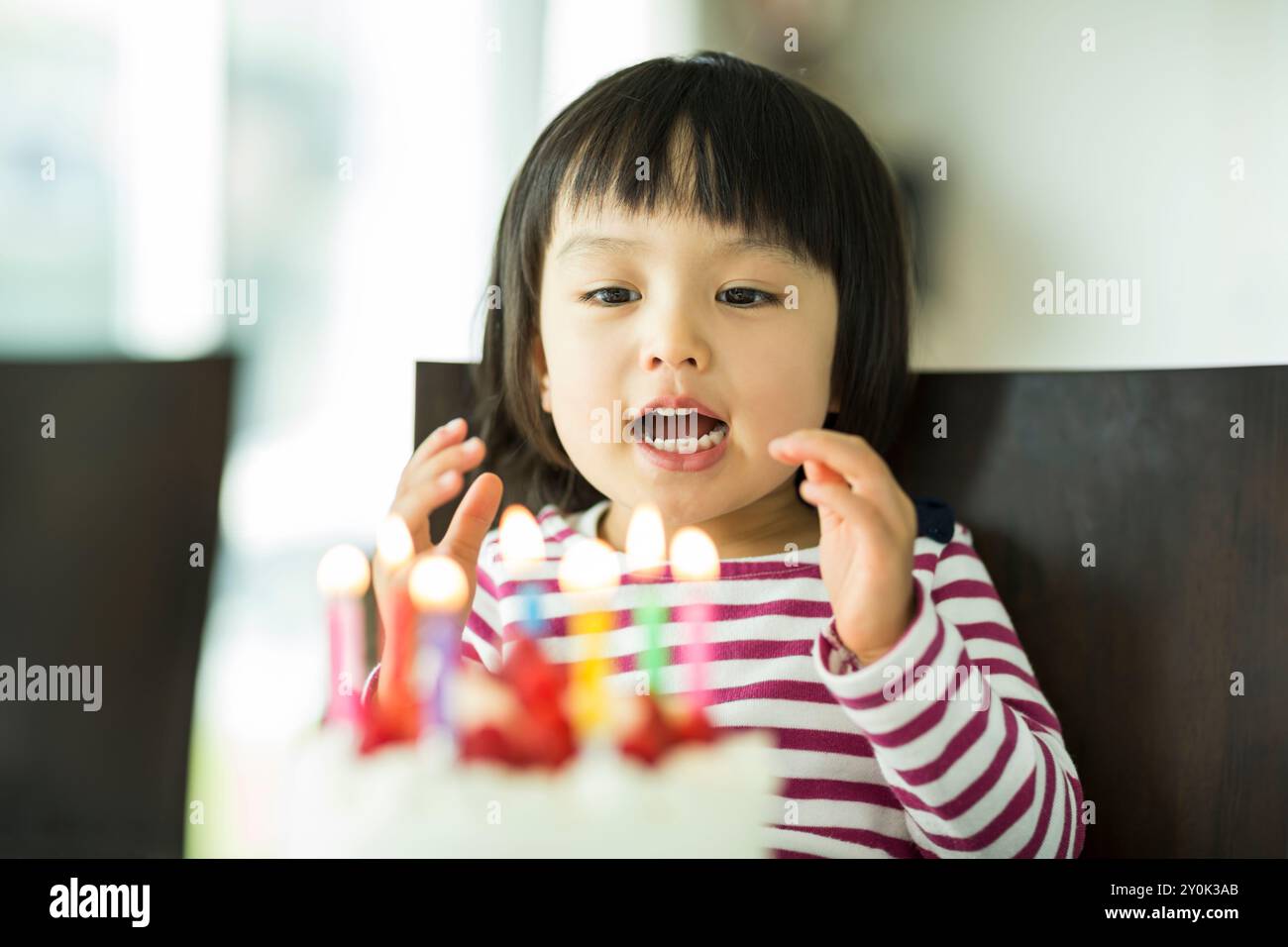 Girl blowing out the fire of the candle Stock Photo - Alamy