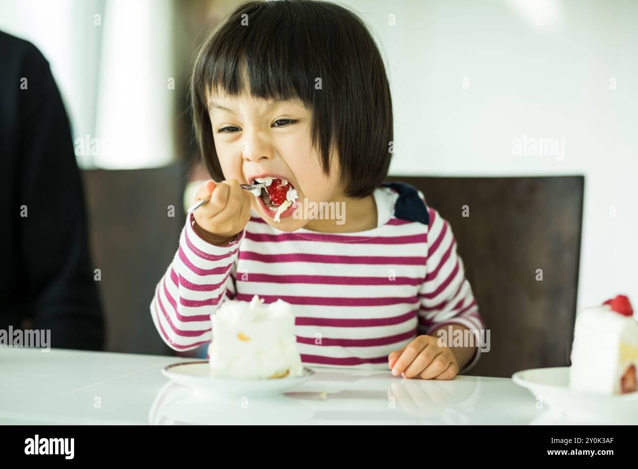 Girl eating cake Stock Photo - Alamy