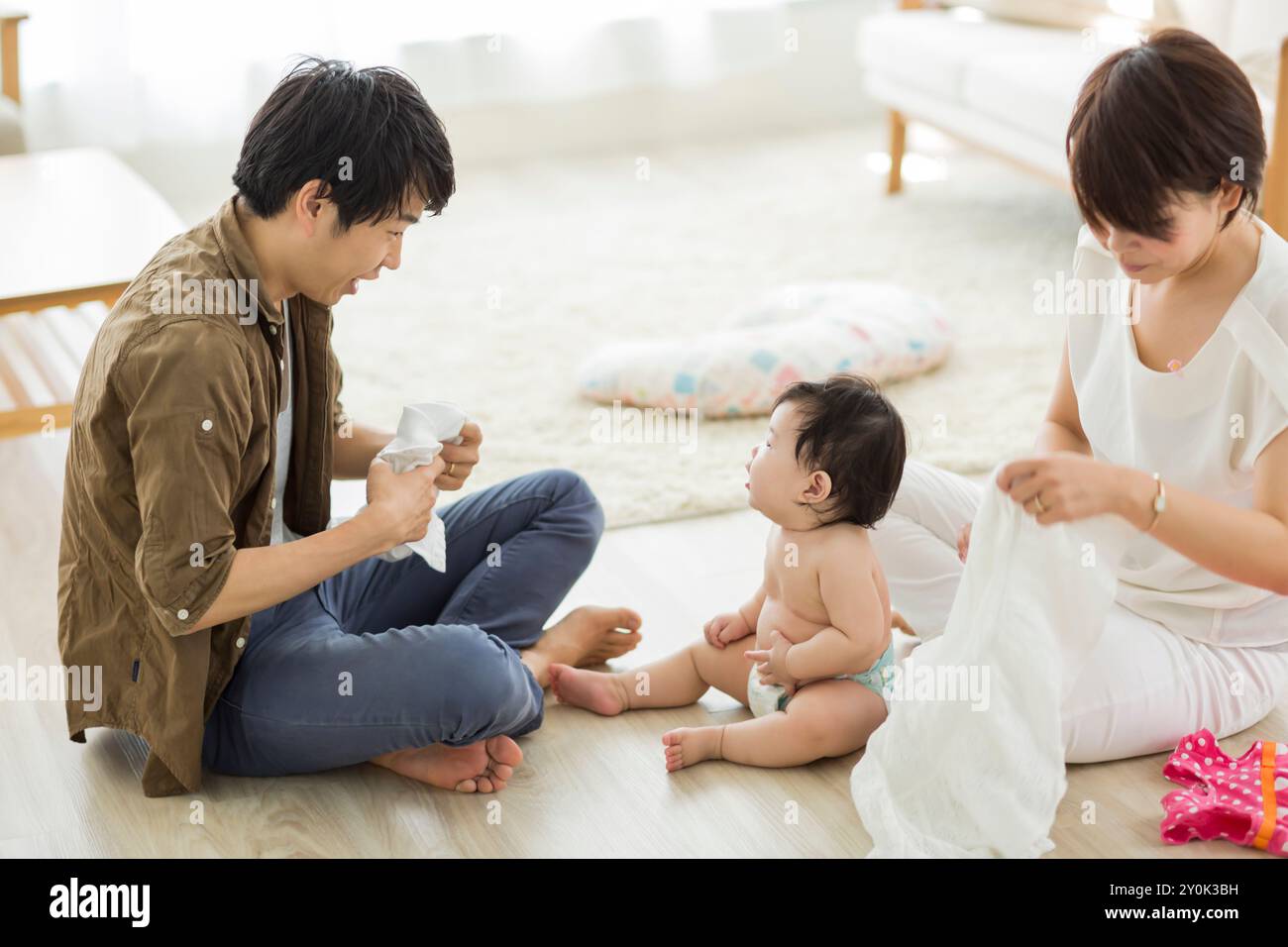 Parents getting their baby changed Stock Photo - Alamy