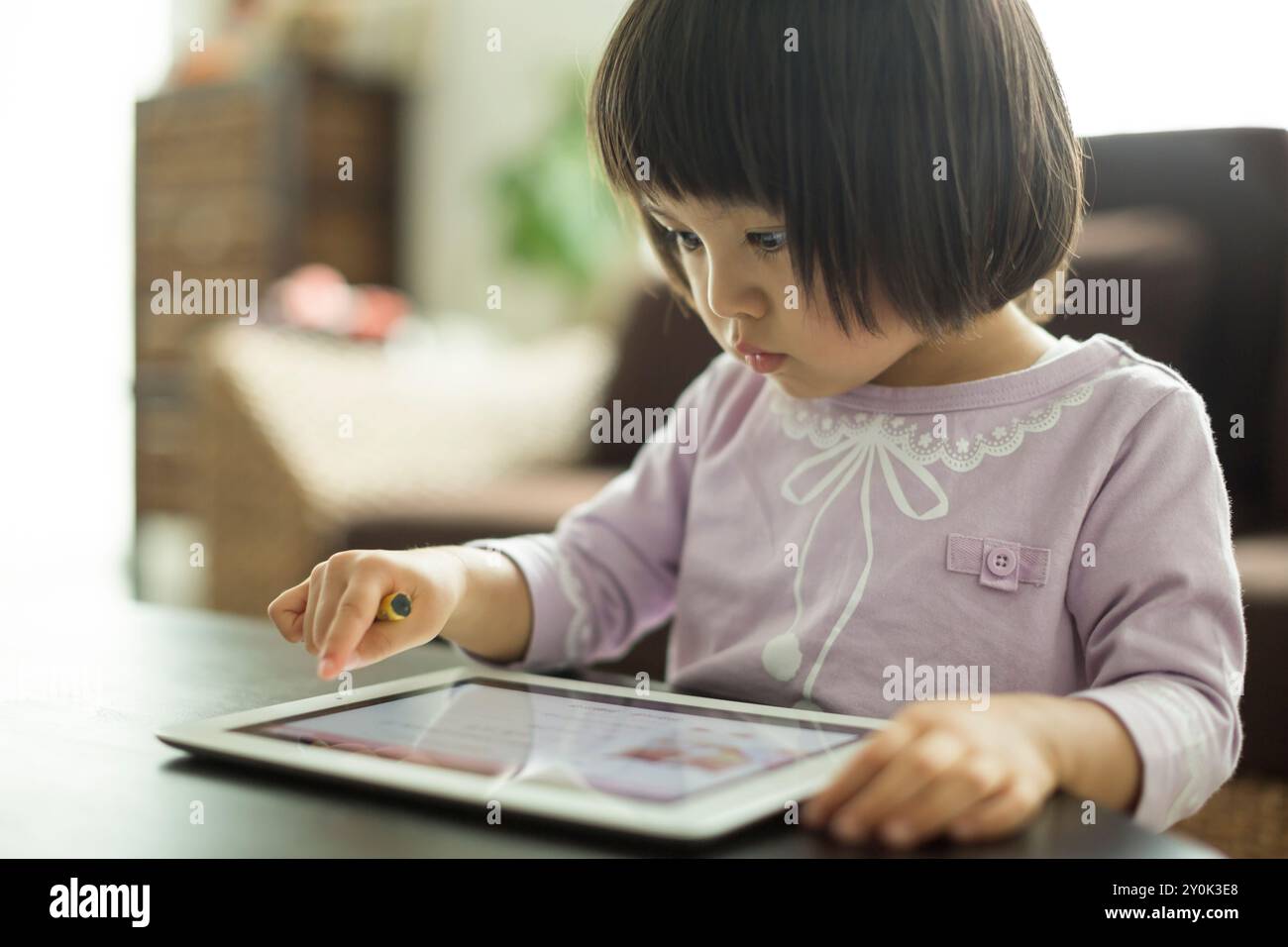 Girl playing with the tablet Stock Photo - Alamy