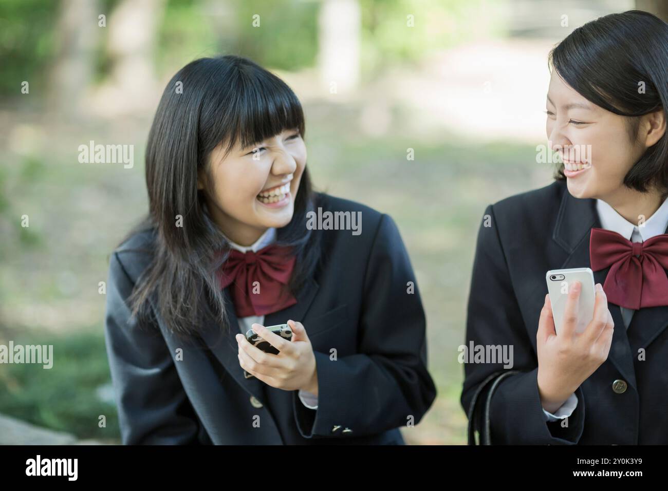 High school girls having a conversation on a mobile phones Stock Photo ...