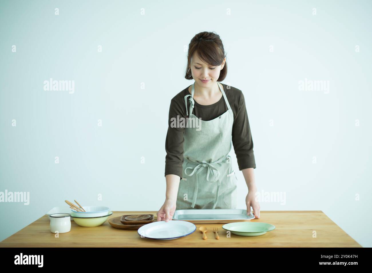 Woman removing dishes from table Stock Photo - Alamy