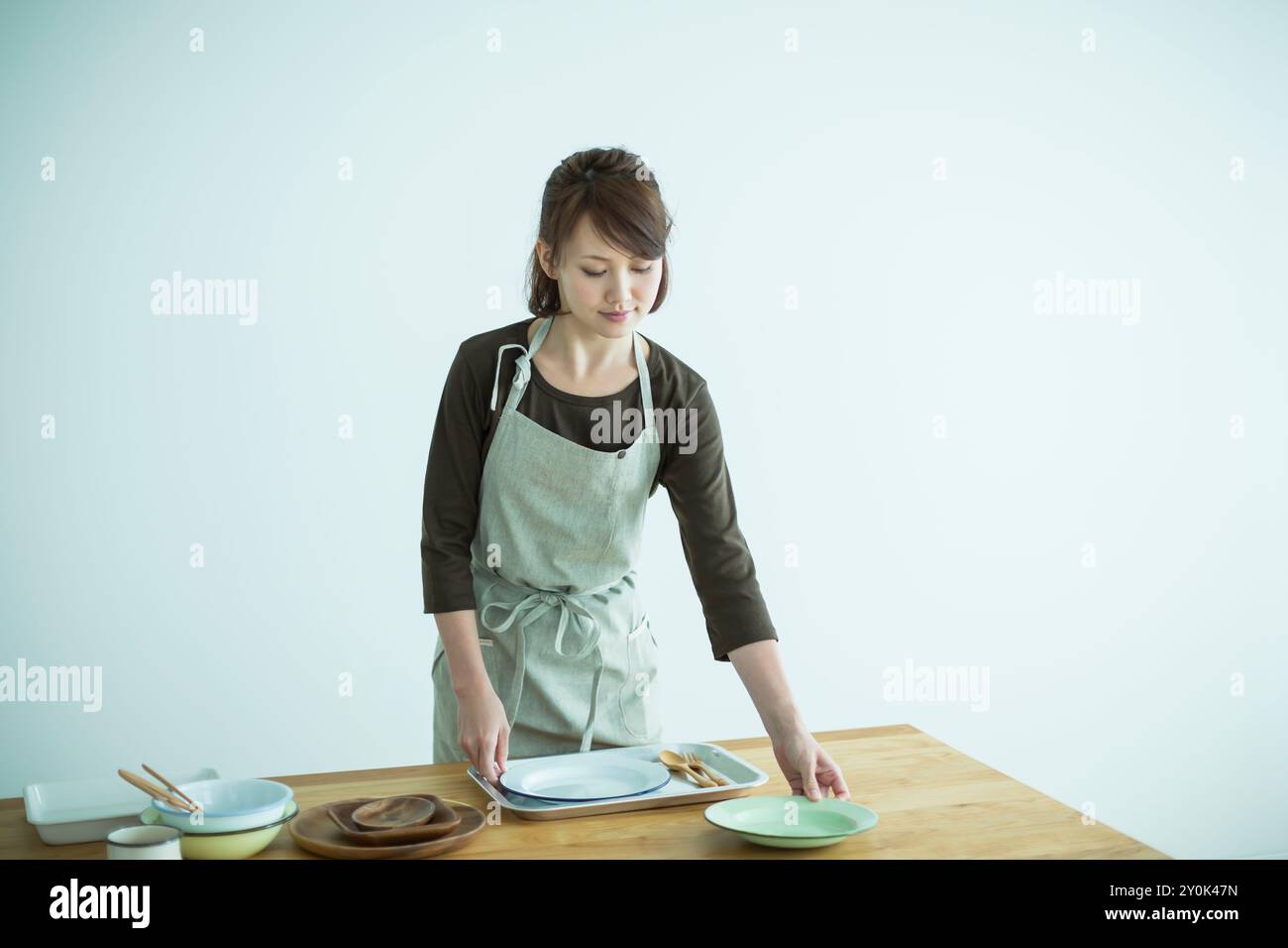 Woman removing dishes from table Stock Photo - Alamy