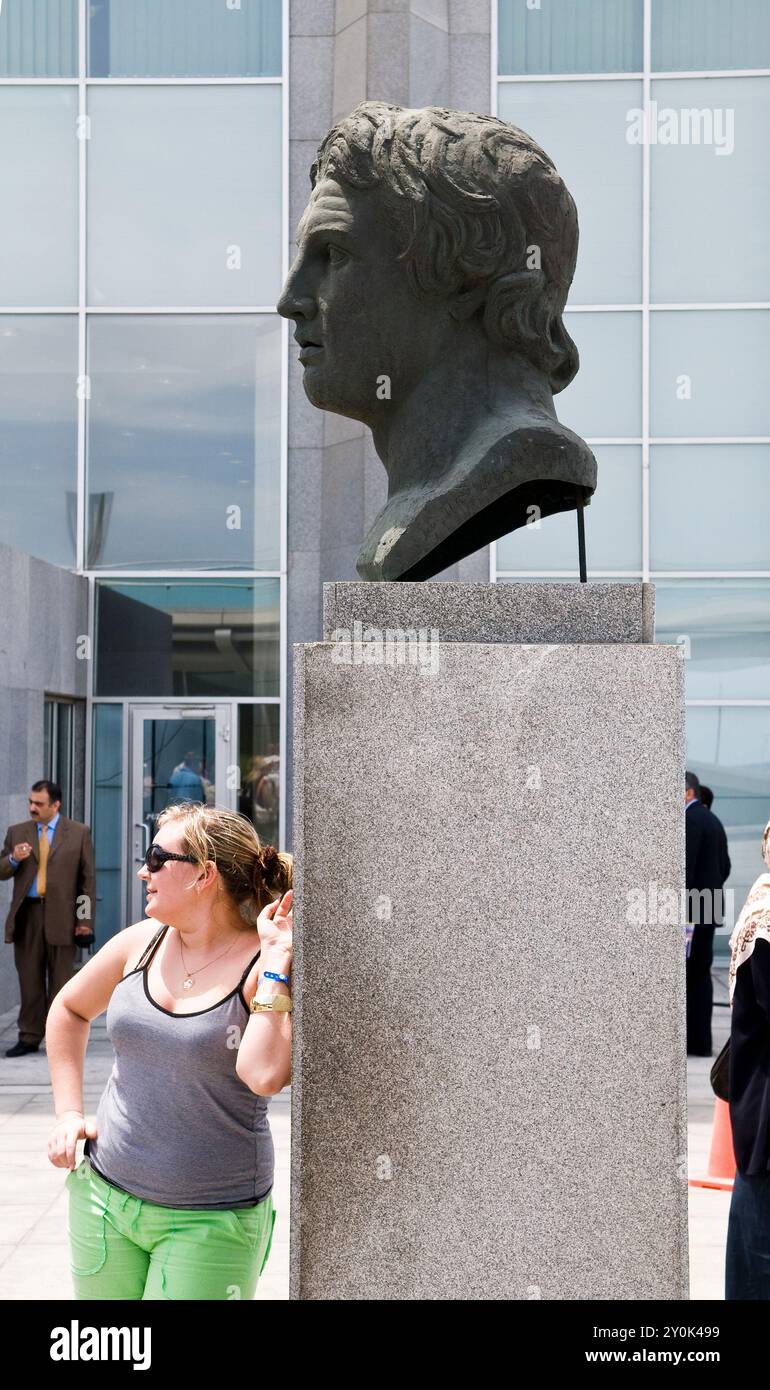 Tourist posing by a statue of Alexander The Great by the library in ...