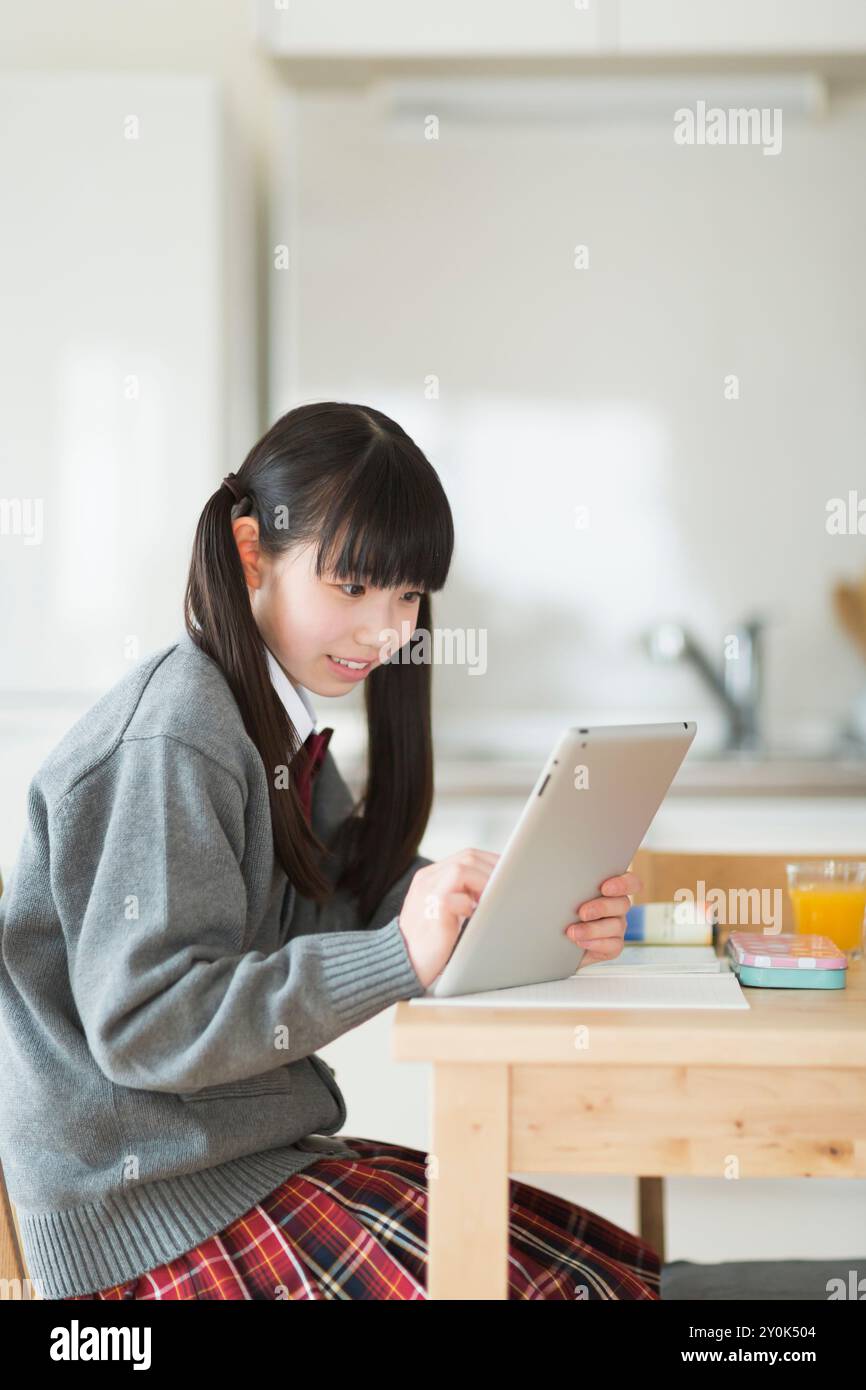 Junior high school girl studying with a tablet Stock Photo - Alamy