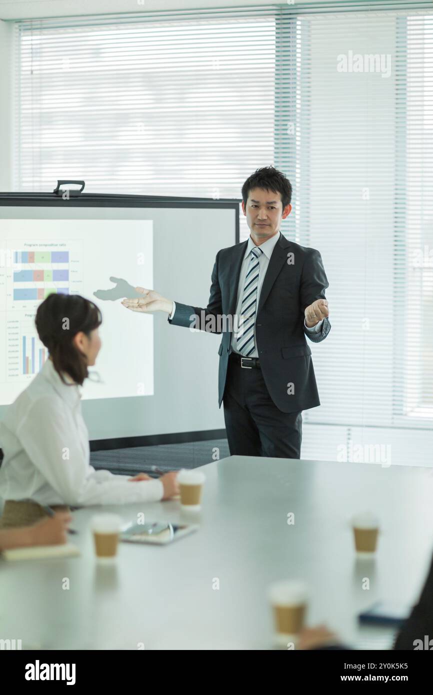 The businessman who explains at the meeting which uses a projector ...