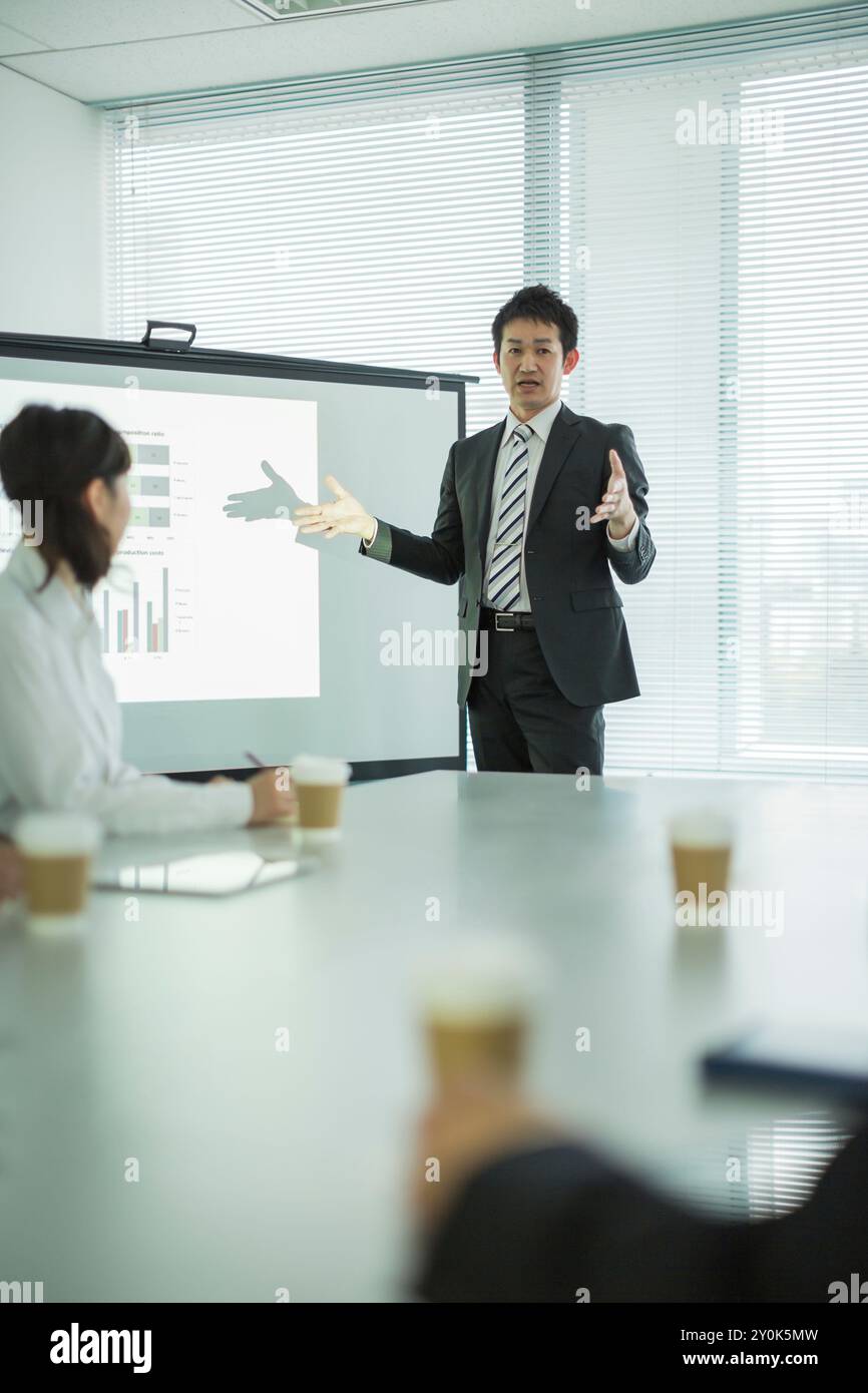 The businessman who explains at the meeting which uses a projector ...
