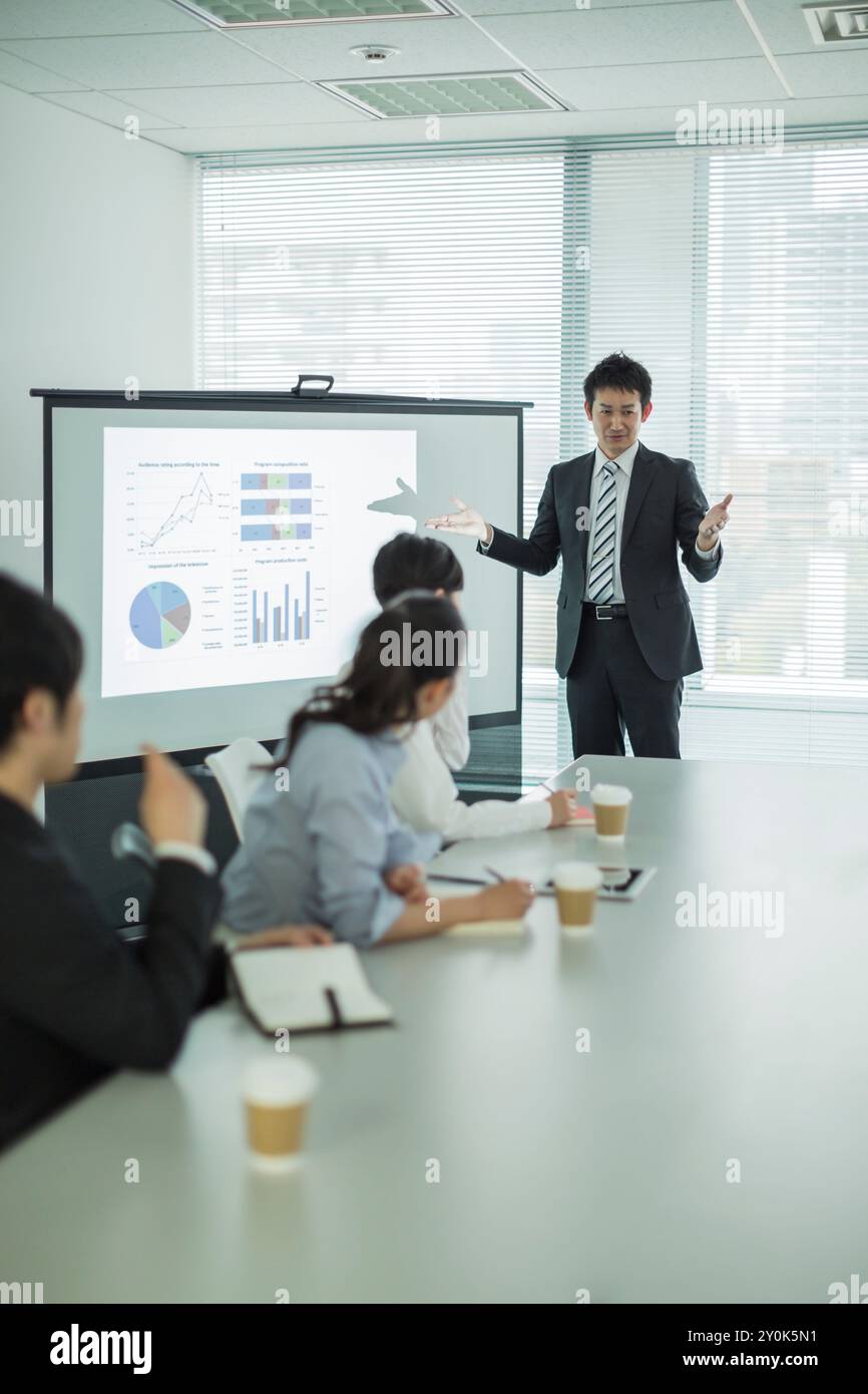 The businessman who explains at the meeting which uses a projector ...