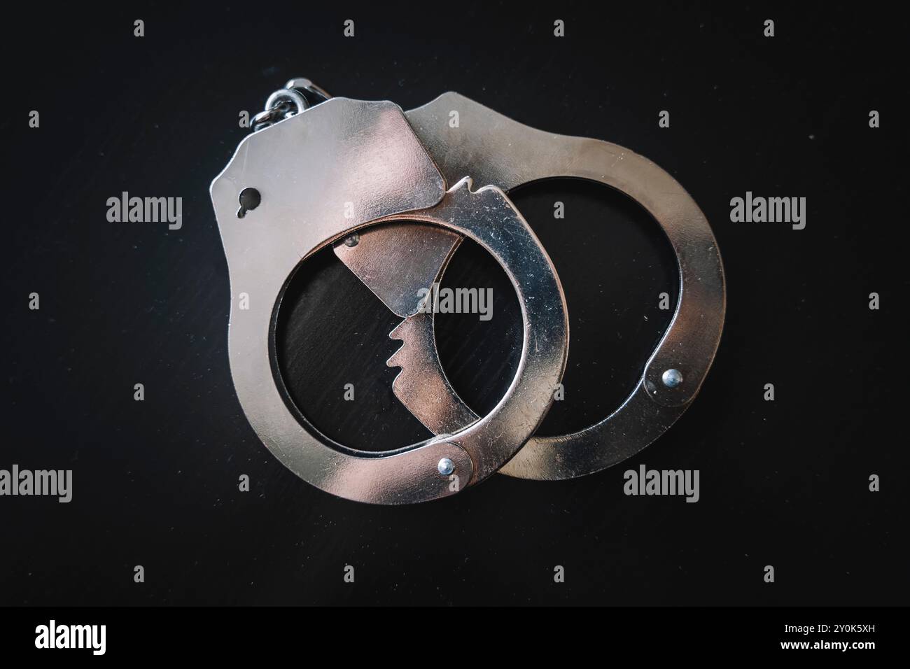 the concept of arrest and crime. metal handcuffs on a black table ...