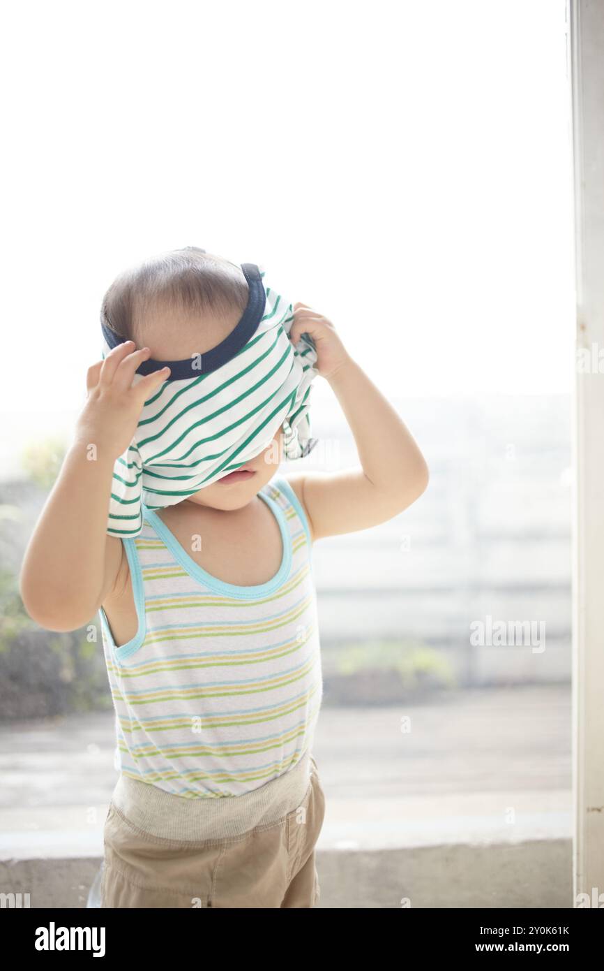 Kid trying to change his own clothes Stock Photo - Alamy