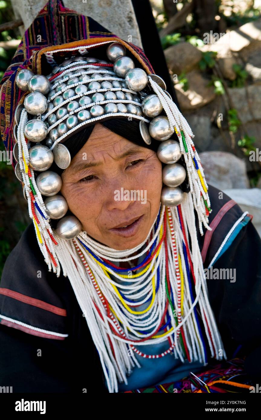 Portrait of an Akha woman wearing her traditional dress and head wear ...
