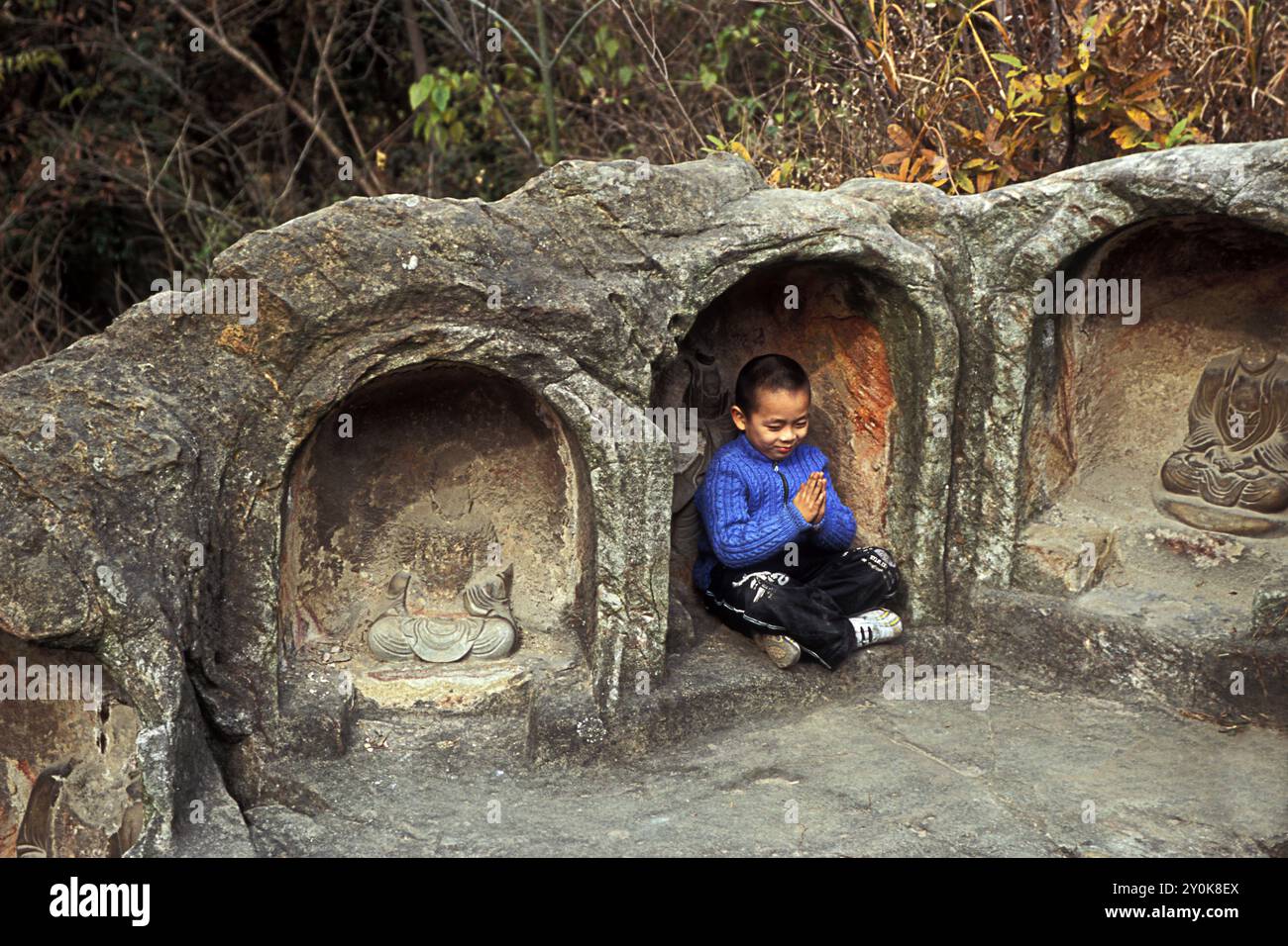 A young boy enjoys the moment in one of the many caves in Qi Xia temple ...