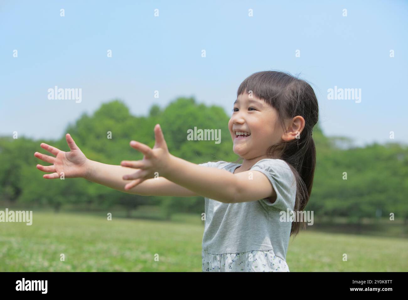 Girl stretching hands with smile Stock Photo - Alamy