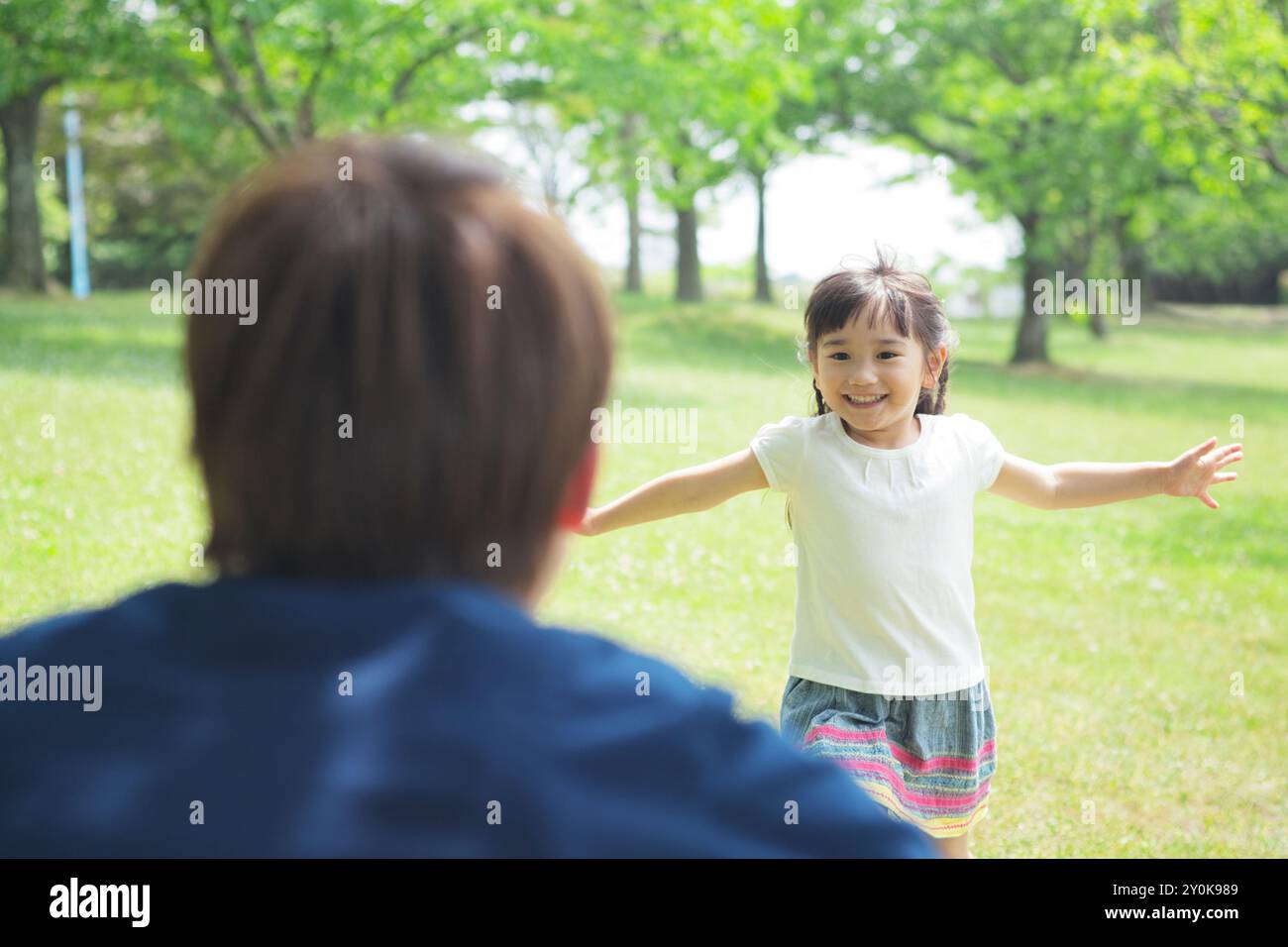 Smiling daughter running toward her father Stock Photo - Alamy