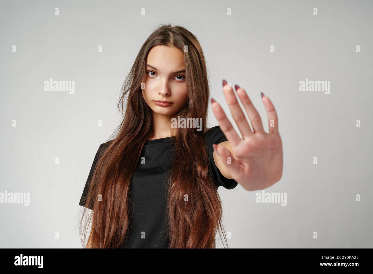 Young Woman Posing With Hand Raised Sign Stock Photo - Alamy