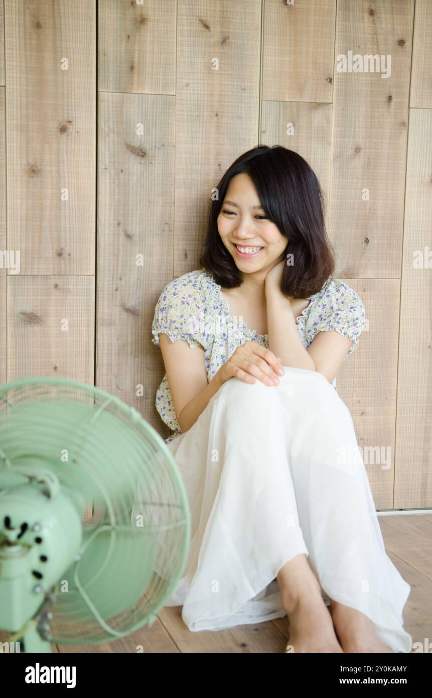 Woman relaxing in front of an electric fan Stock Photo - Alamy