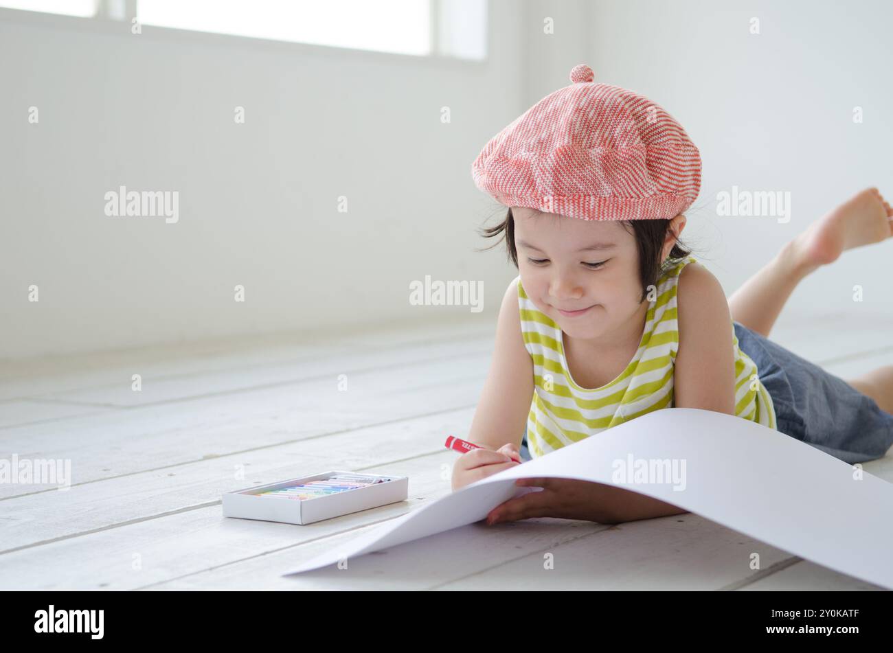 Girl lying on the floor while drawing pictures Stock Photo - Alamy