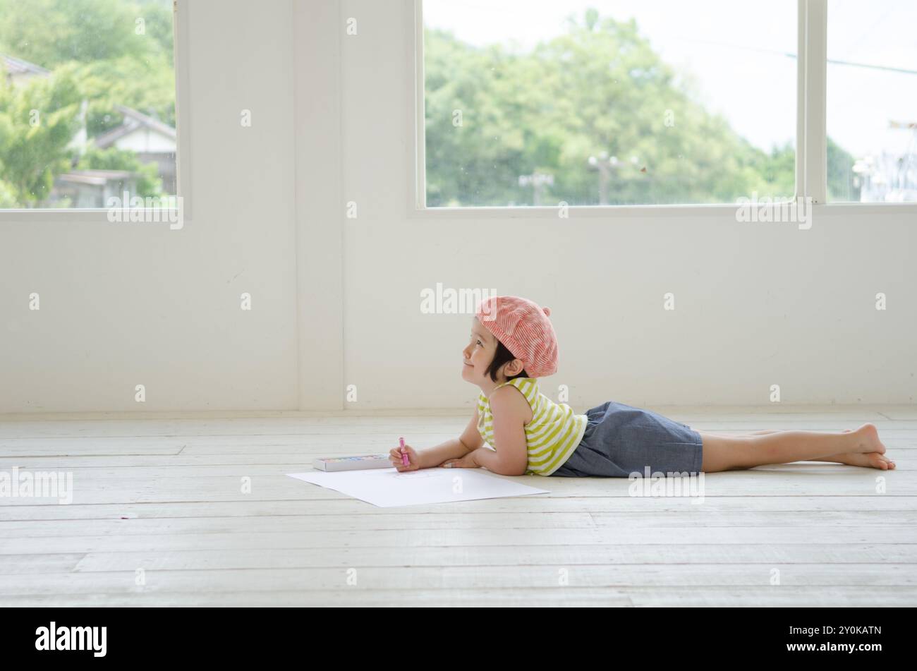 Girl lying on the floor while drawing pictures Stock Photo - Alamy