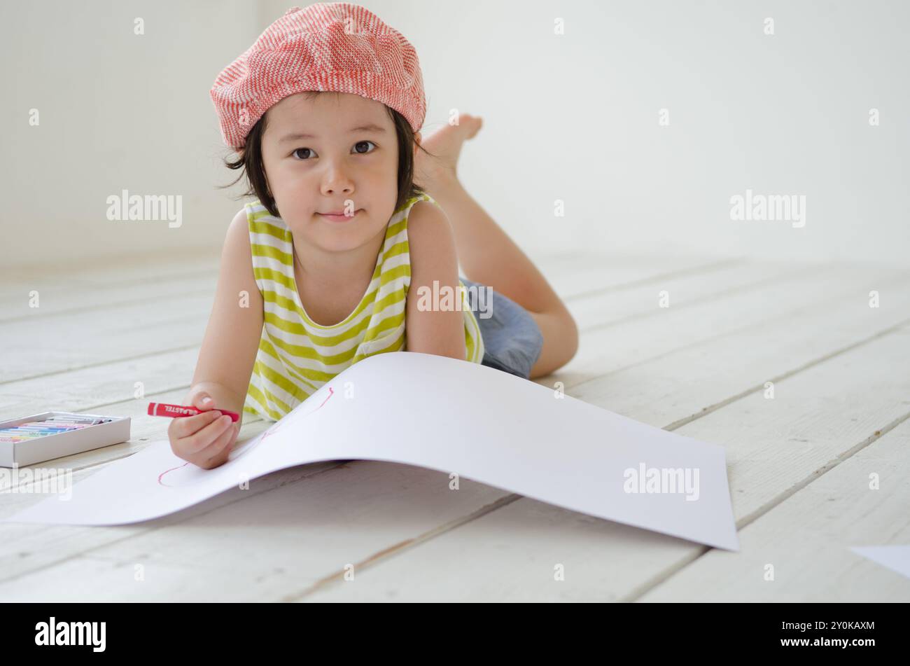 Girl lying on the floor while drawing pictures Stock Photo - Alamy
