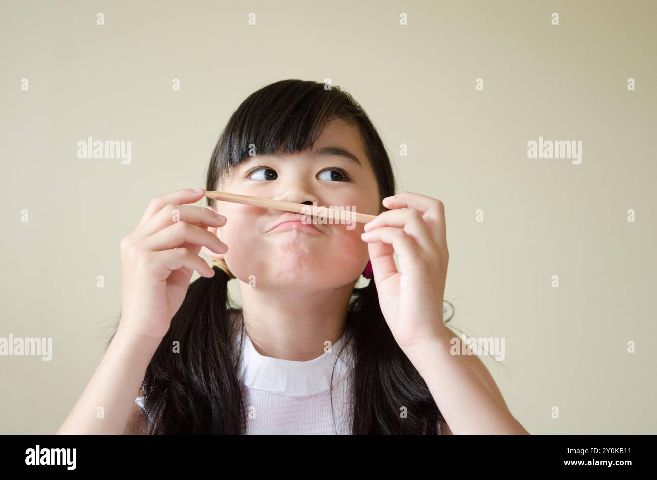Zany face girl with a pencil Stock Photo - Alamy